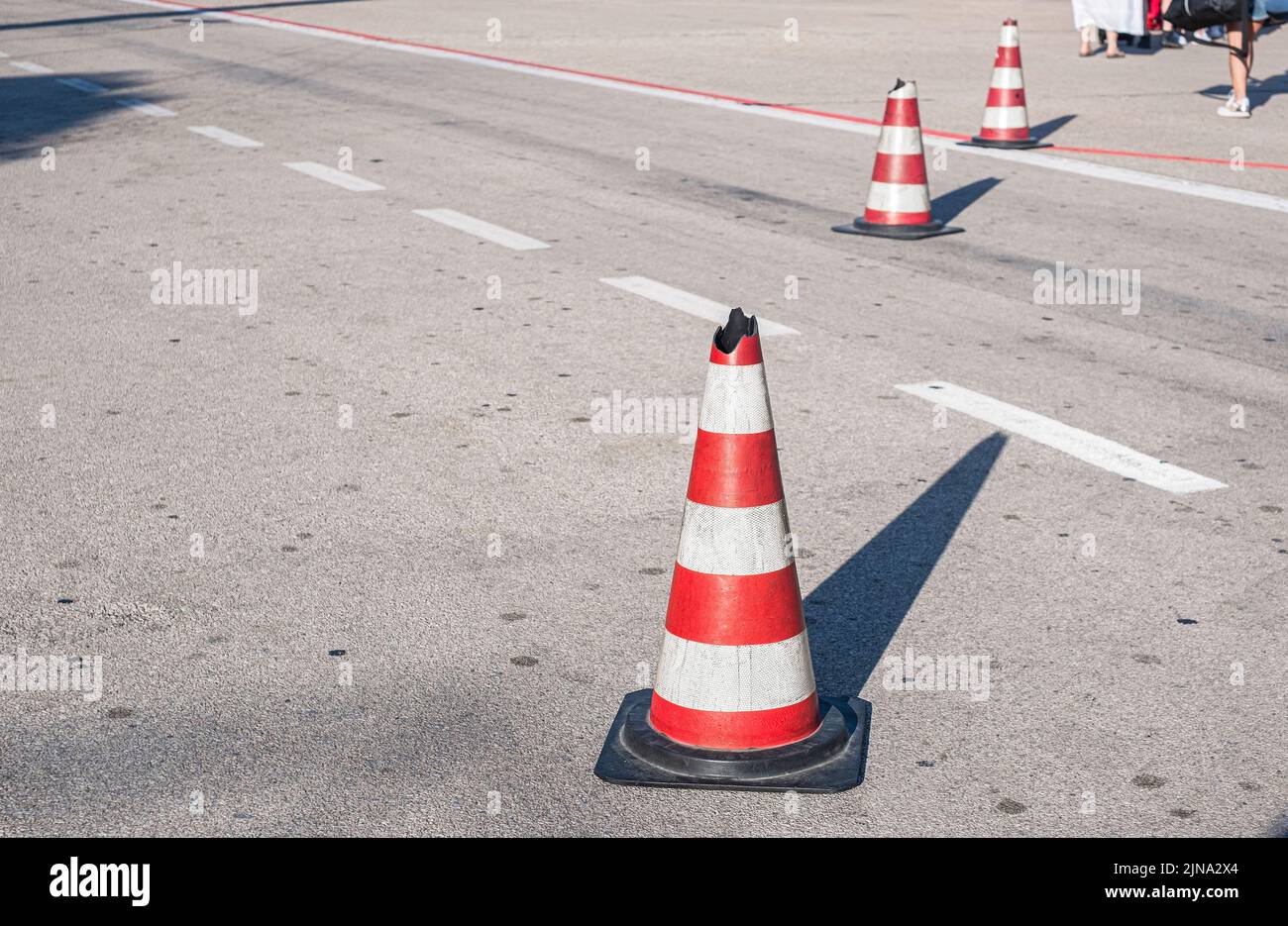 Traffic cones with white and red stripes on the road of the airport ...