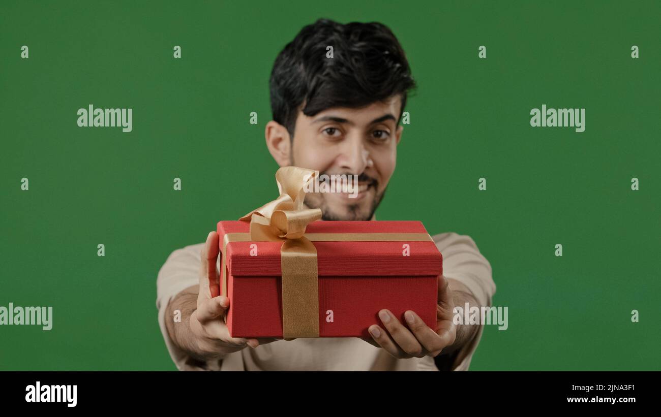 Hispanic happy man giving gift large red box with gold ribbon studio ...