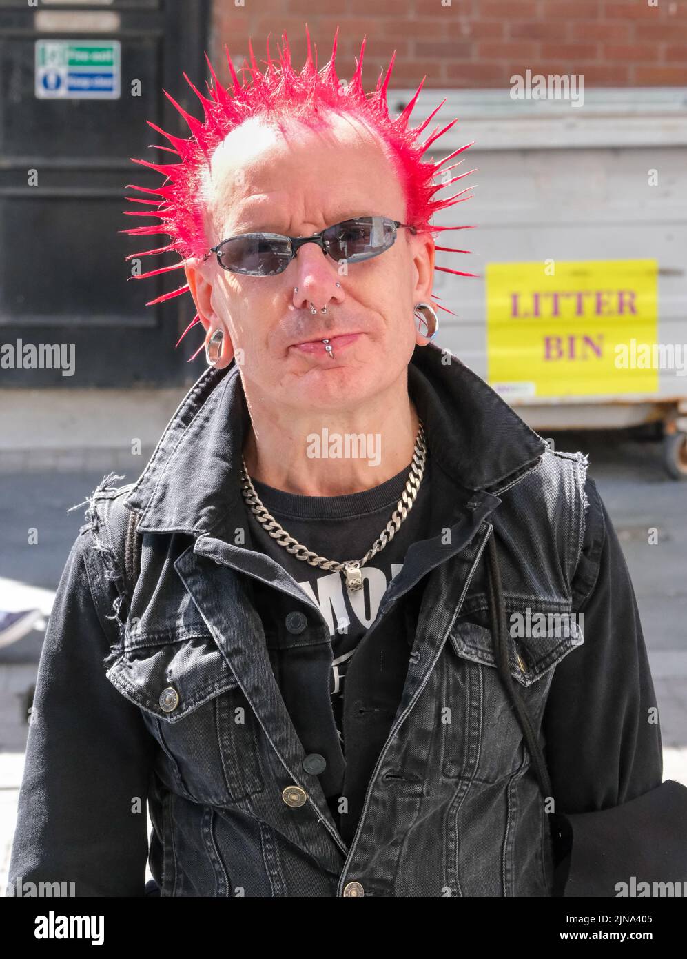 Blackpool, Lancashire, UK August 6 2022 A male punk with bright red ...