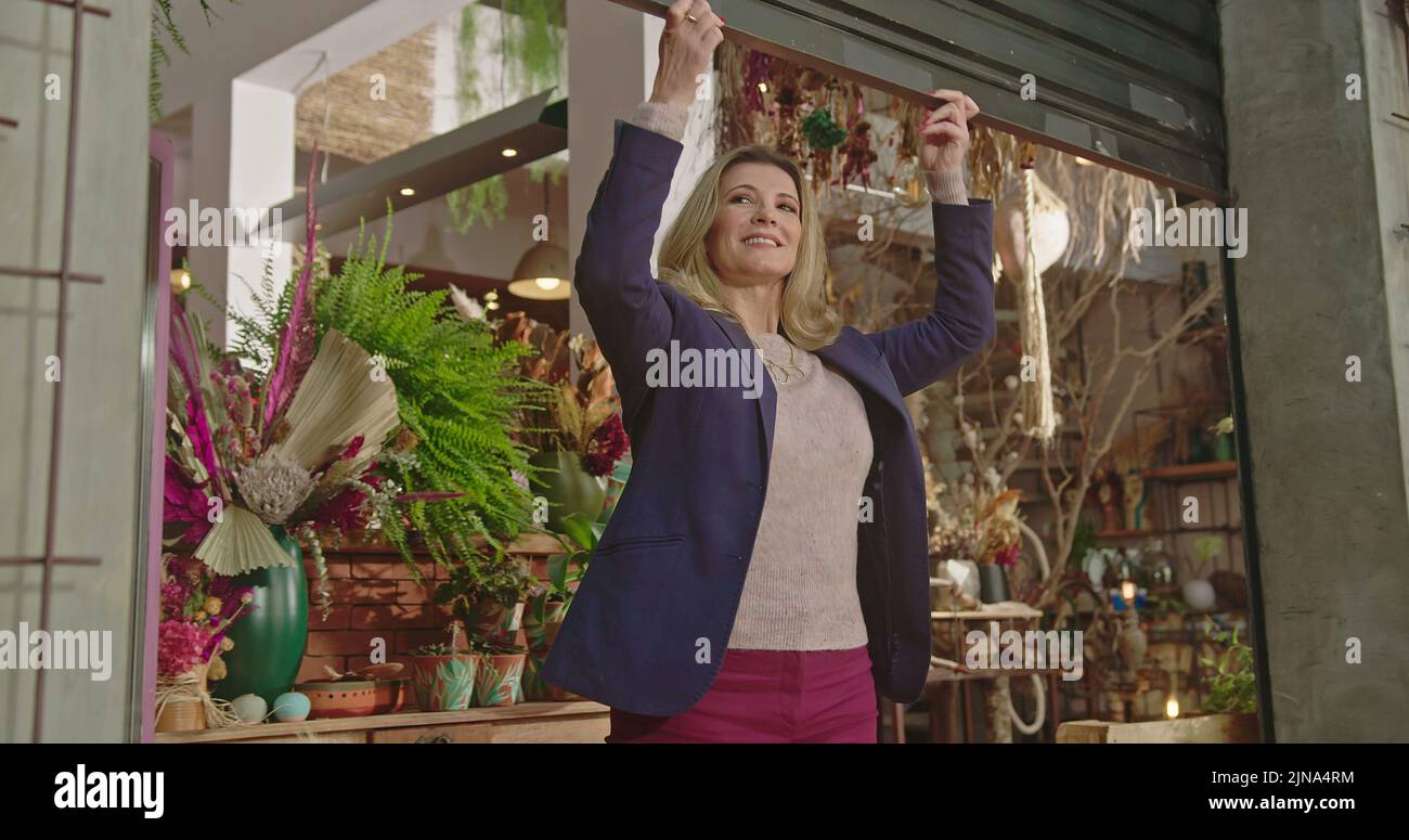 Small business owner opening local store. Female entrepreneur sliding ...