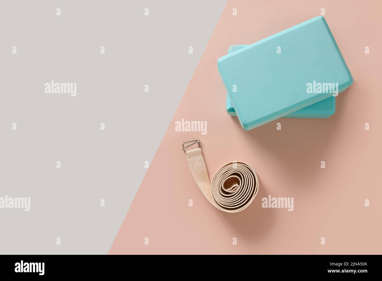 Green yoga blocks and white strap on beige background. Yoga practice ...