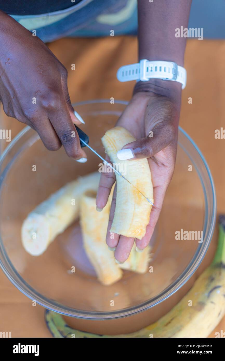 woman chef preparing african caribbean food with plantain plane tree ...