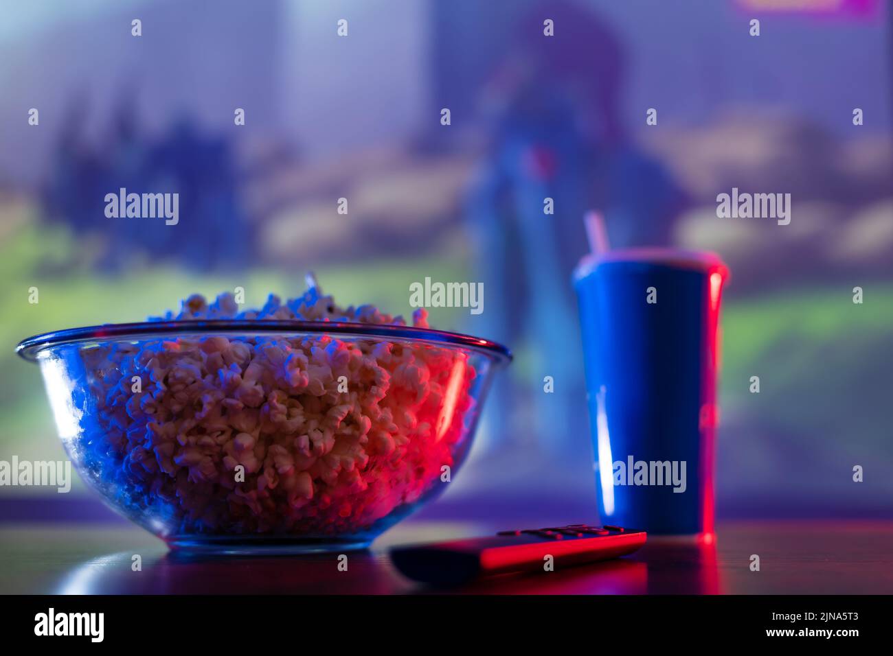 Fast food - popcorn in a glass bowl, a soda drink in a plastic glass ...