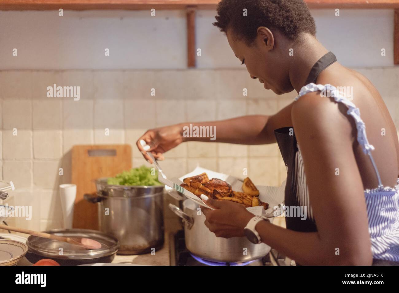 woman chef preparing african caribbean food with plantain plane tree ...