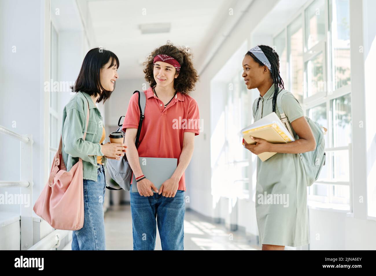 Multiethnic group of students talking to each other during break ...