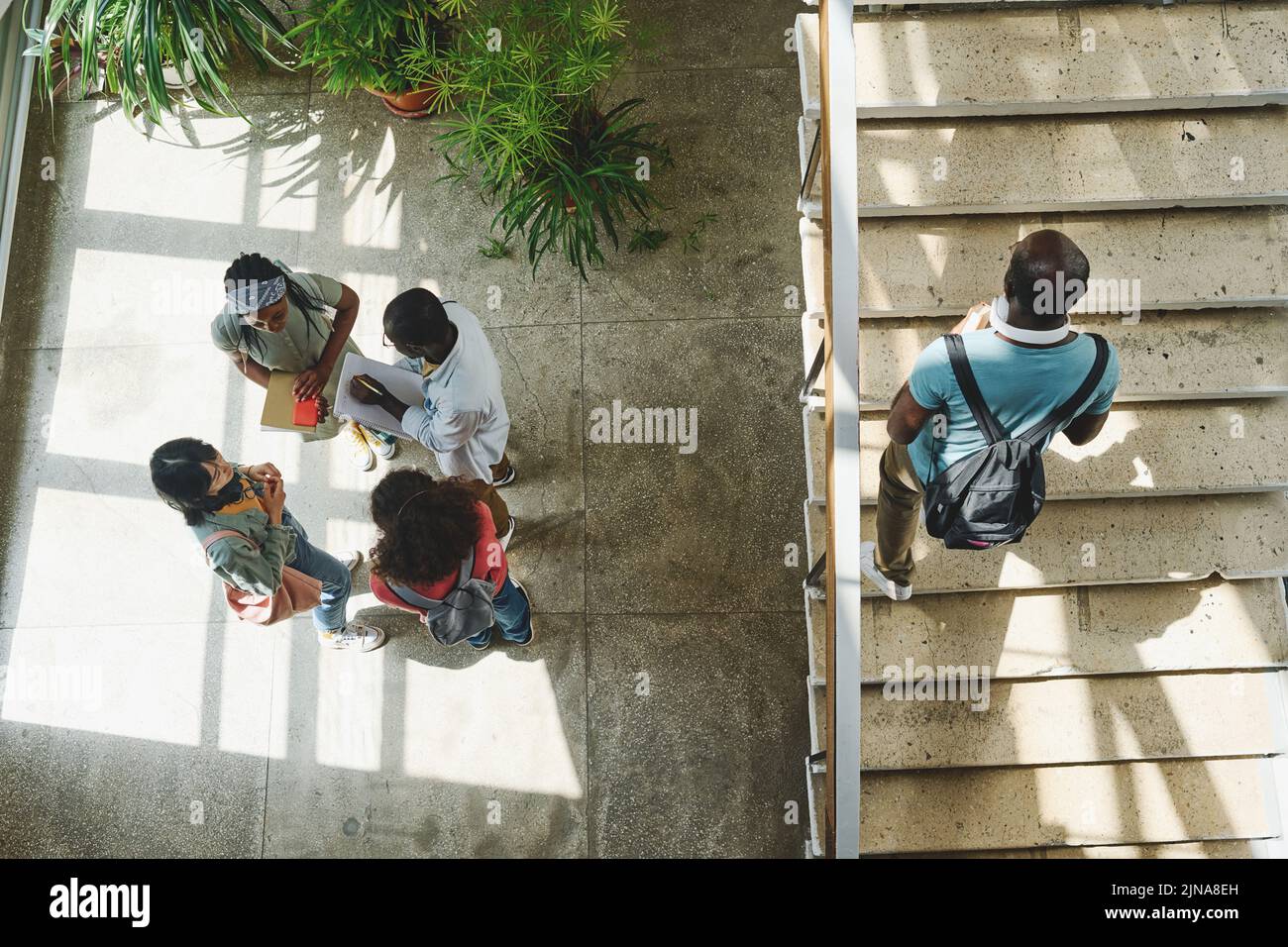 High angle view of group of students standing together and talking at ...