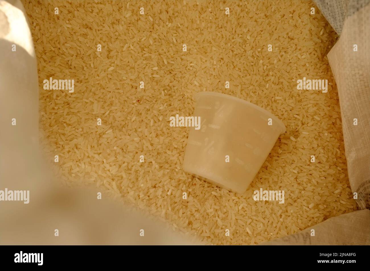 Raw rice with measuring cup Stock Photo - Alamy