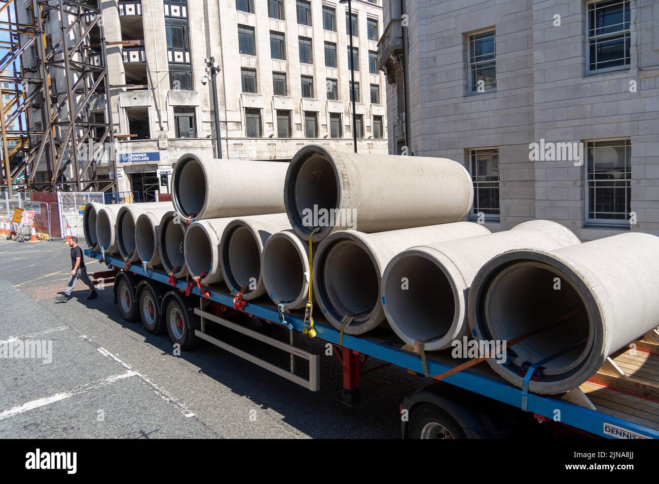 A large batch of concrete drainage pipes being delivered to a building ...