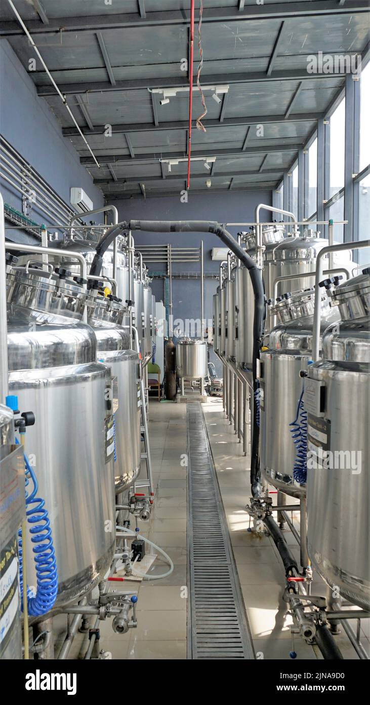 Row of shiny metal micro brewery tanks or Fermentation mash vats in ...