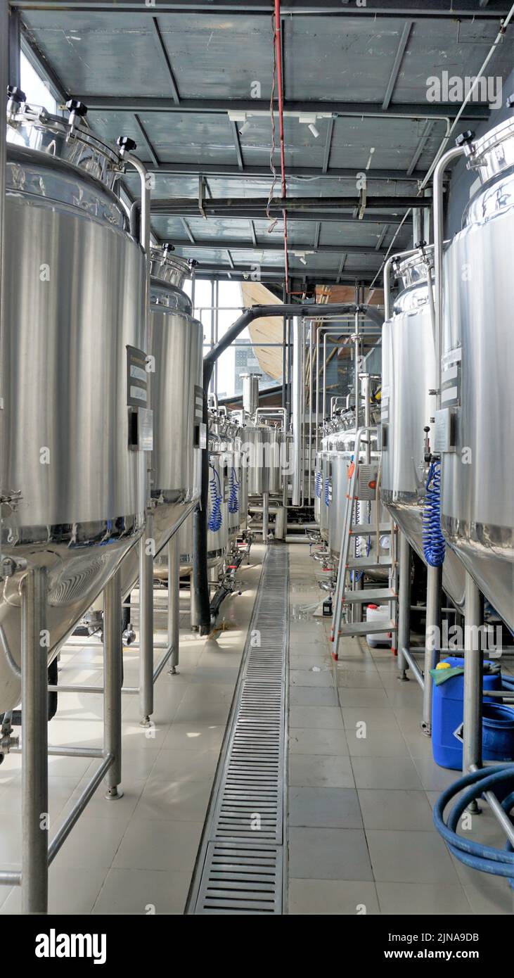 Row of shiny metal micro brewery tanks or Fermentation mash vats in ...