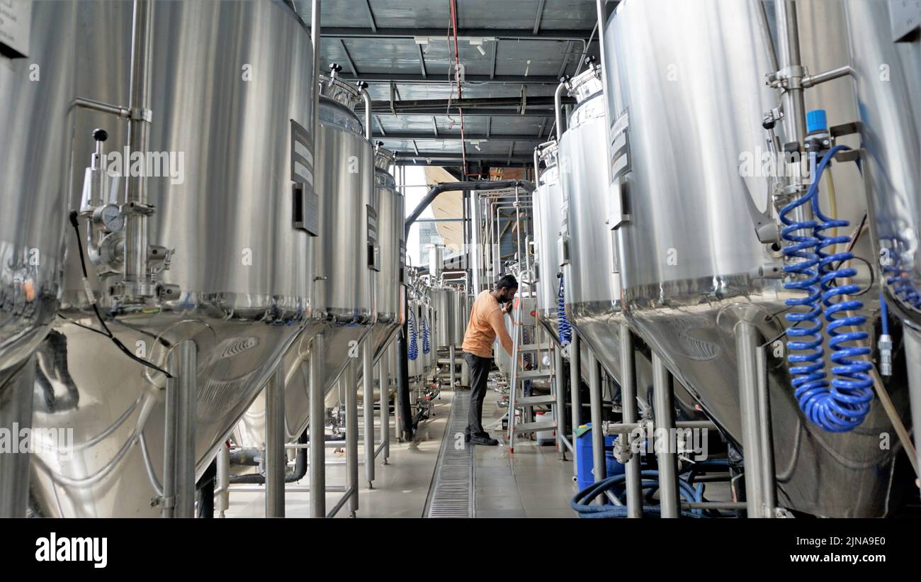 Row of shiny metal micro brewery tanks or Fermentation mash vats in ...