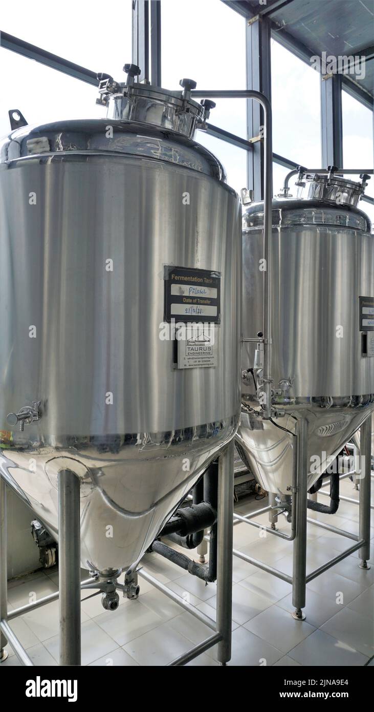 Row of shiny metal micro brewery tanks or Fermentation mash vats in ...