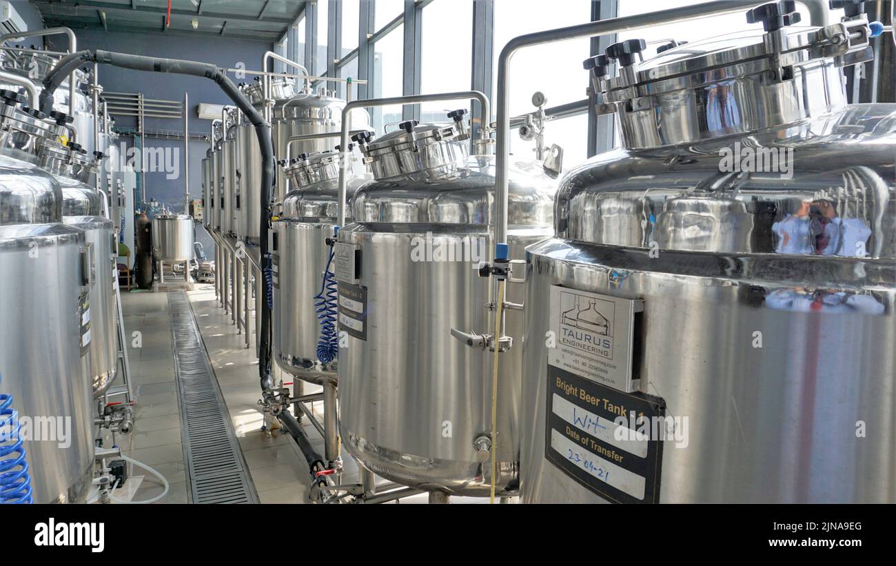 Row of shiny metal micro brewery tanks or Fermentation mash vats in ...