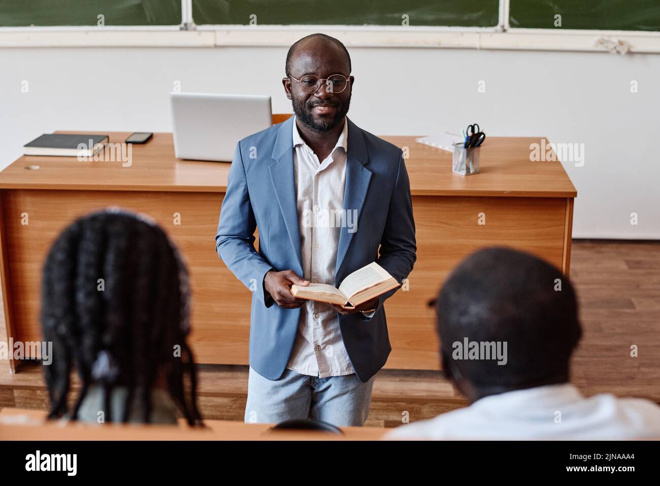African professor reading lecture at university for students while ...