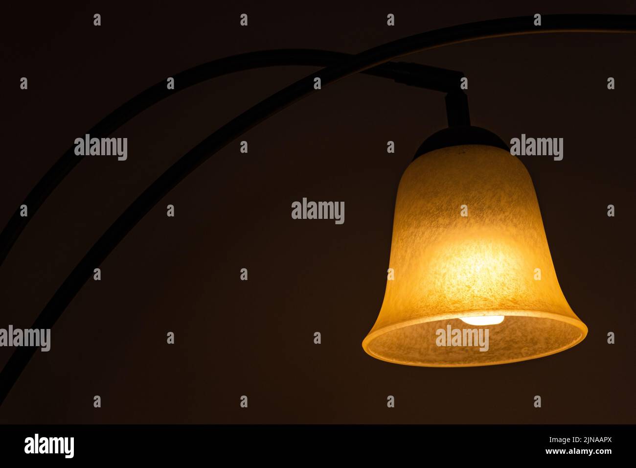 A closeup shot of a yellow bell-shaped lamp in a dark room Stock Photo ...