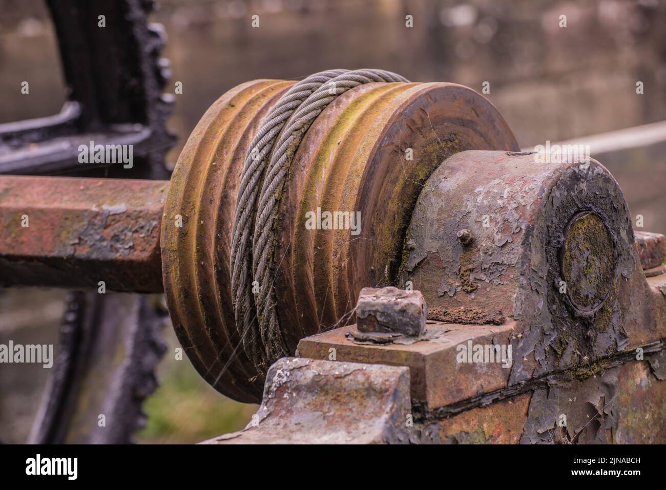 An old rusty pulley wheel and cable, part of a sluice gate mechanism at ...