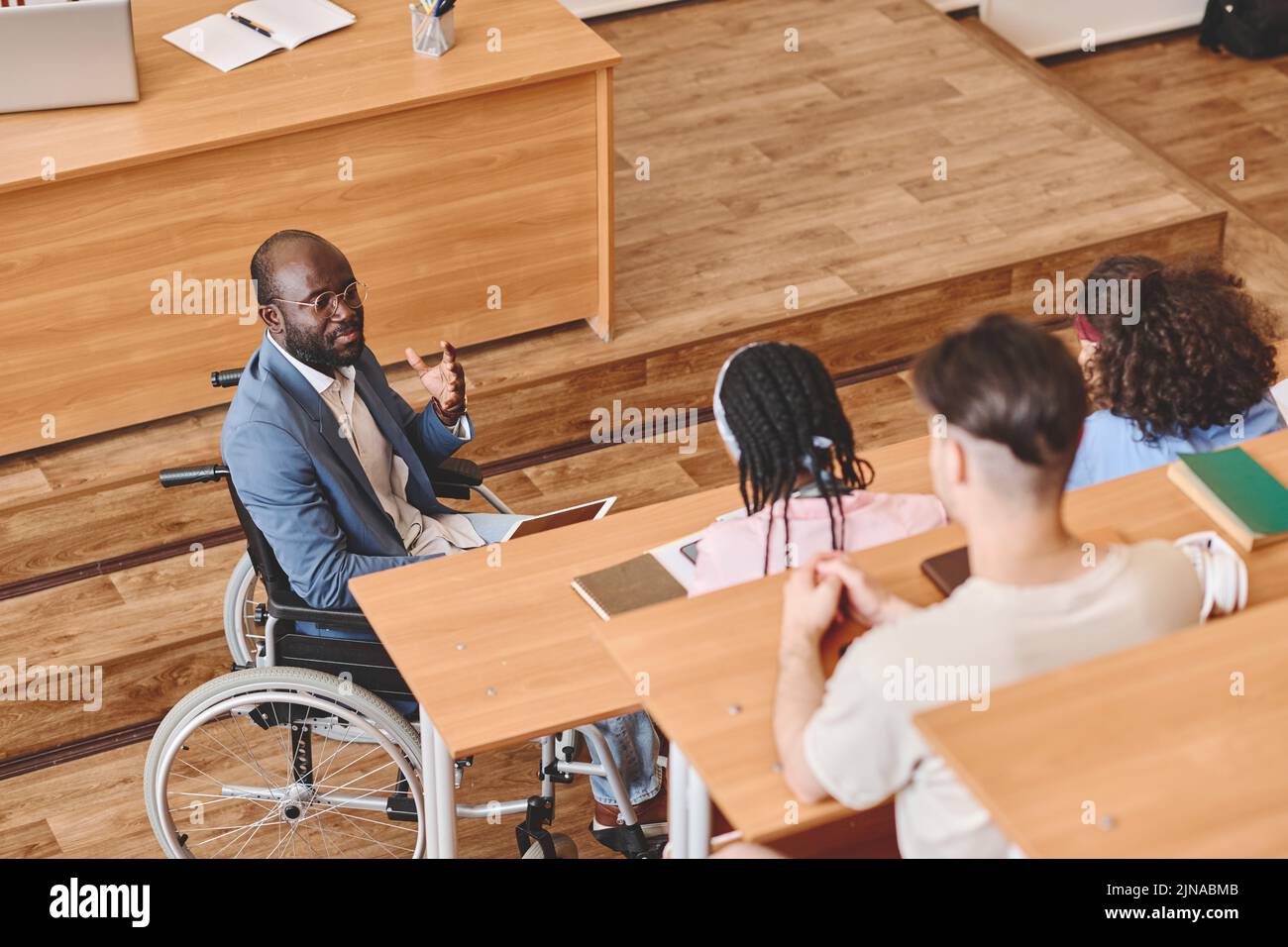 African professor with disability giving lecture to group of students ...