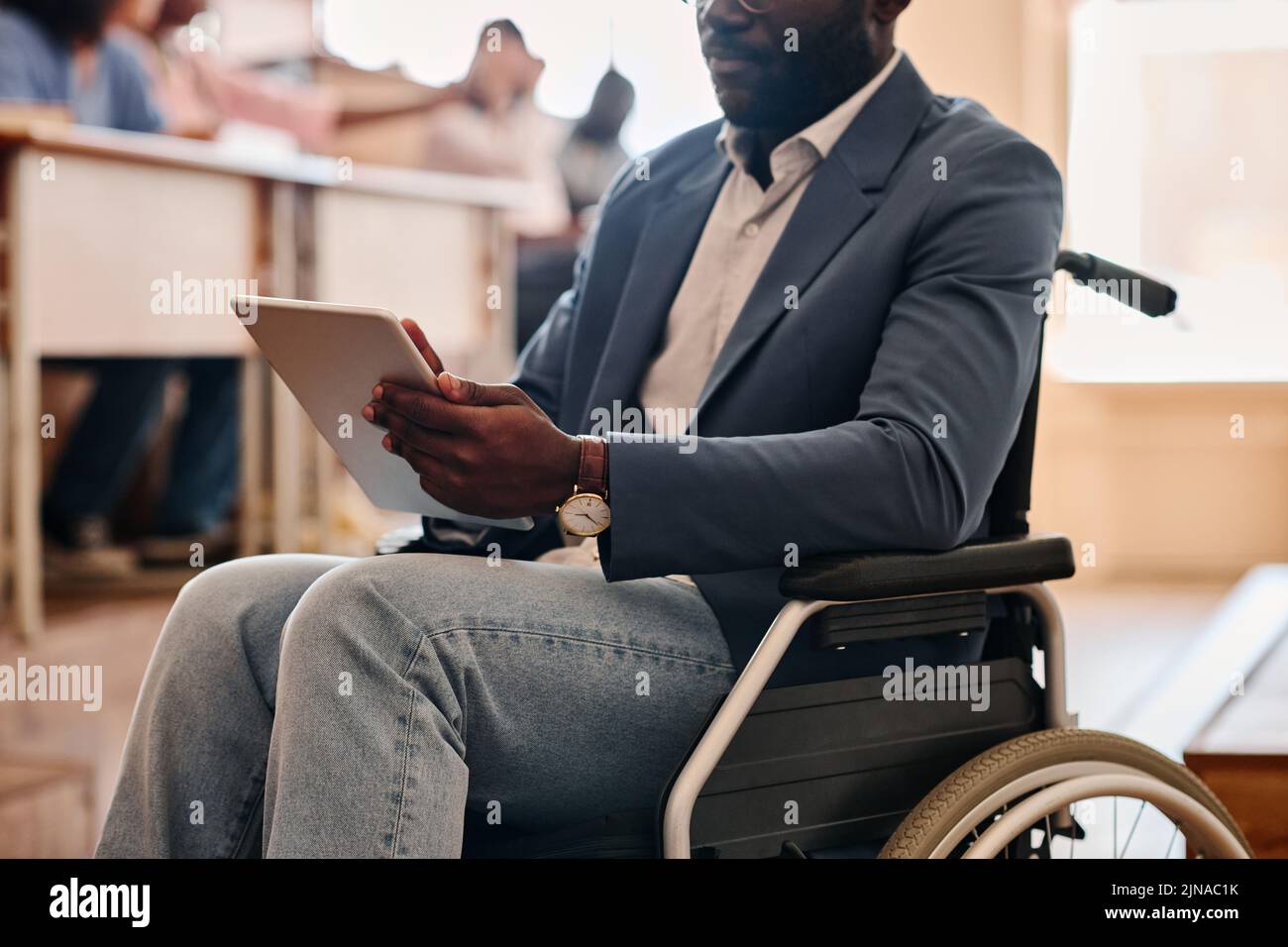 Close-up of African teacher with disability sitting on wheelchair and ...