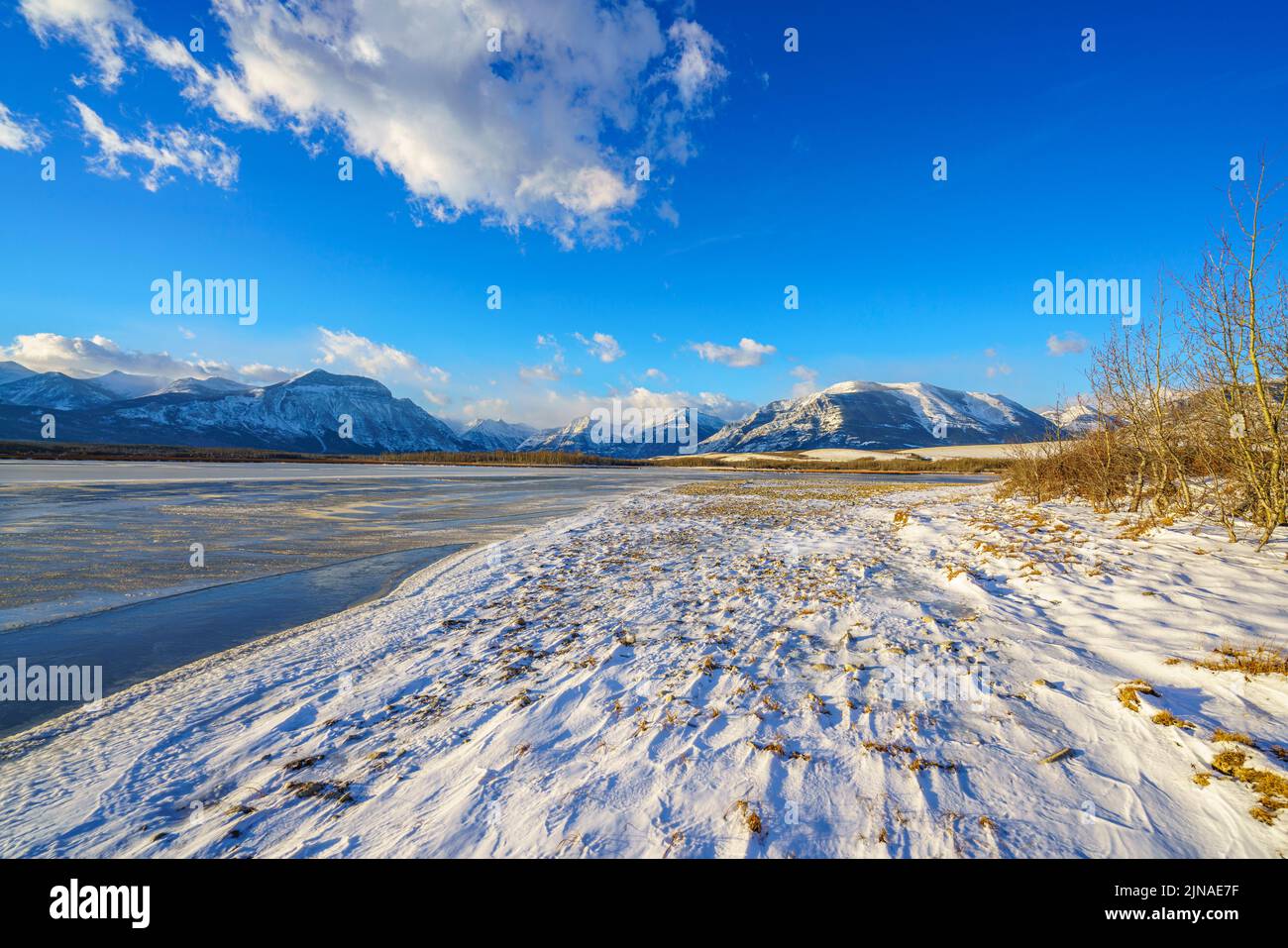The snow-covered shoreline of windswept Maskinonge Lake in Waterton ...