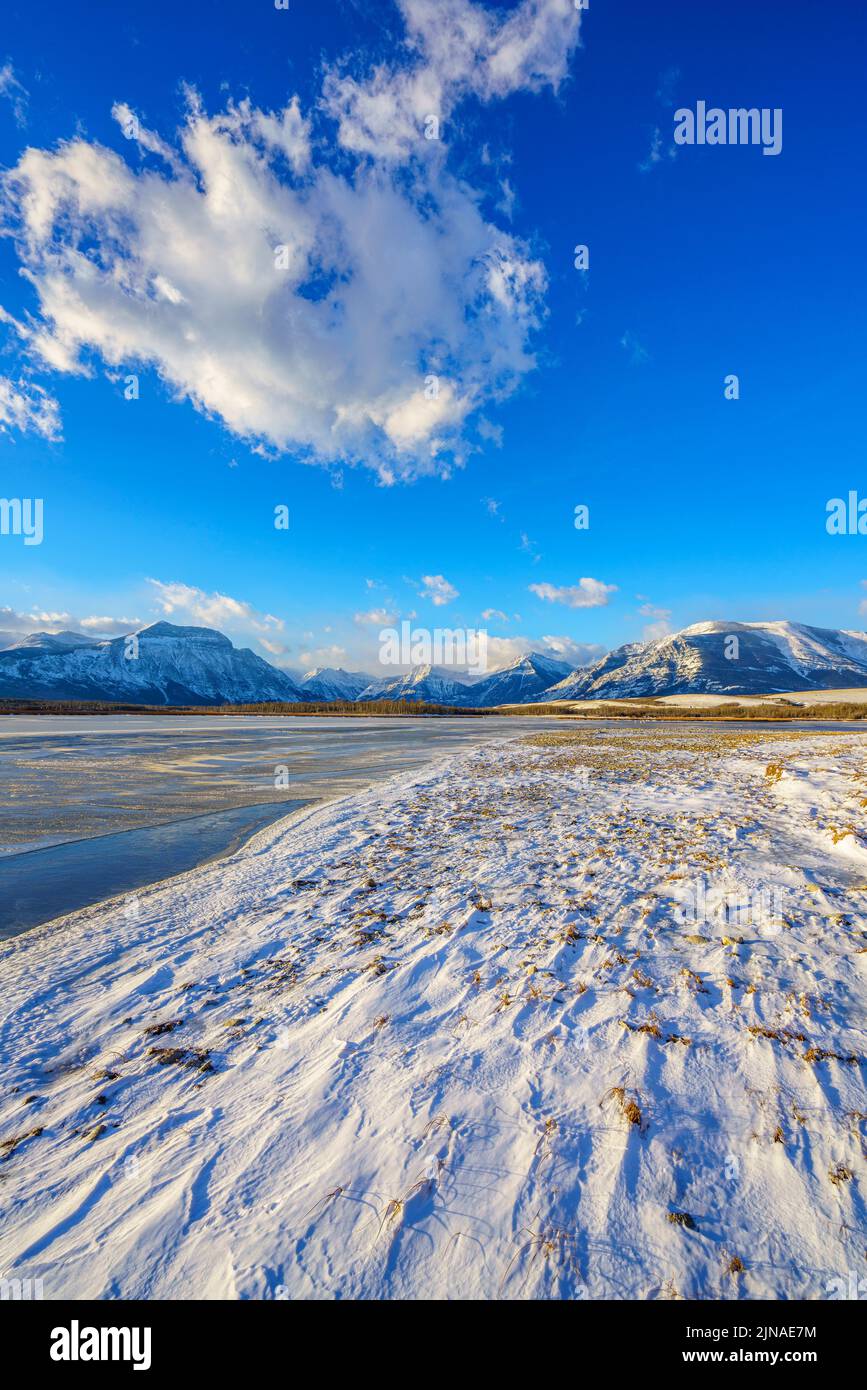 The snow-covered shoreline of windswept Maskinonge Lake in Waterton ...