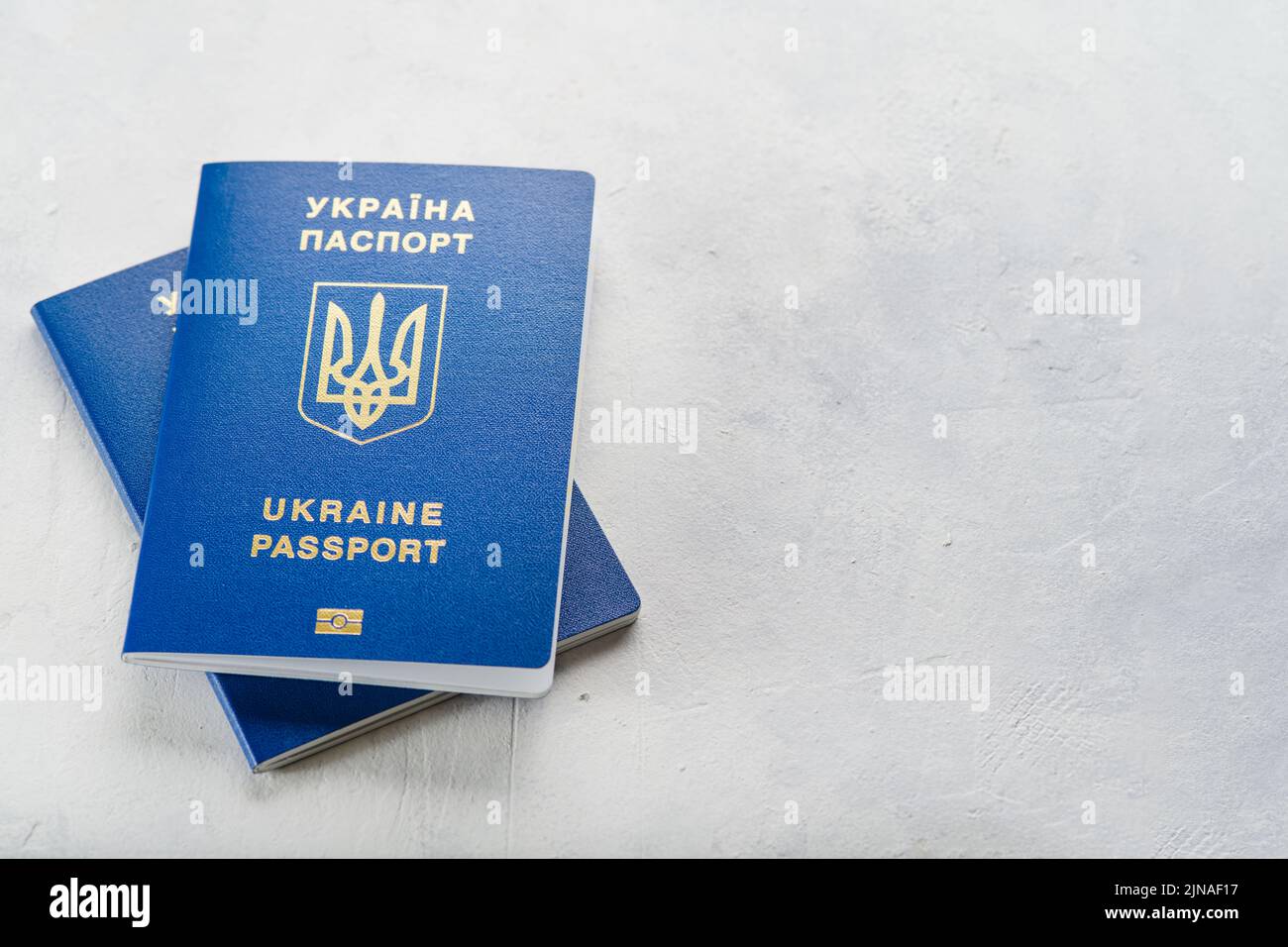 Two blue Ukrainian biometric passports on a white background ...