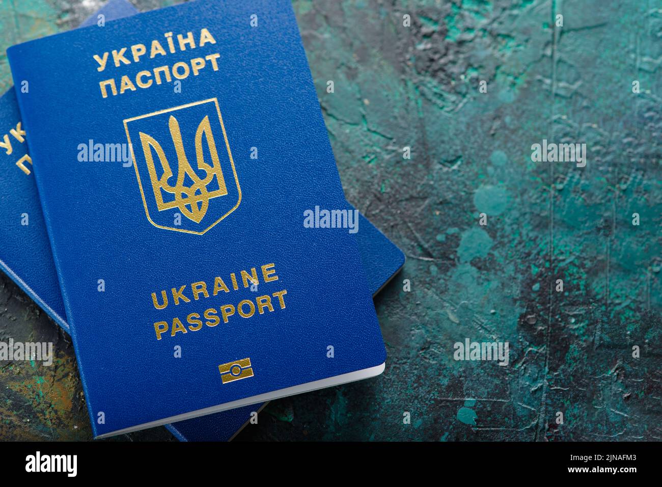 Close-up. On a dark green marble background, two Ukrainian biometric ...