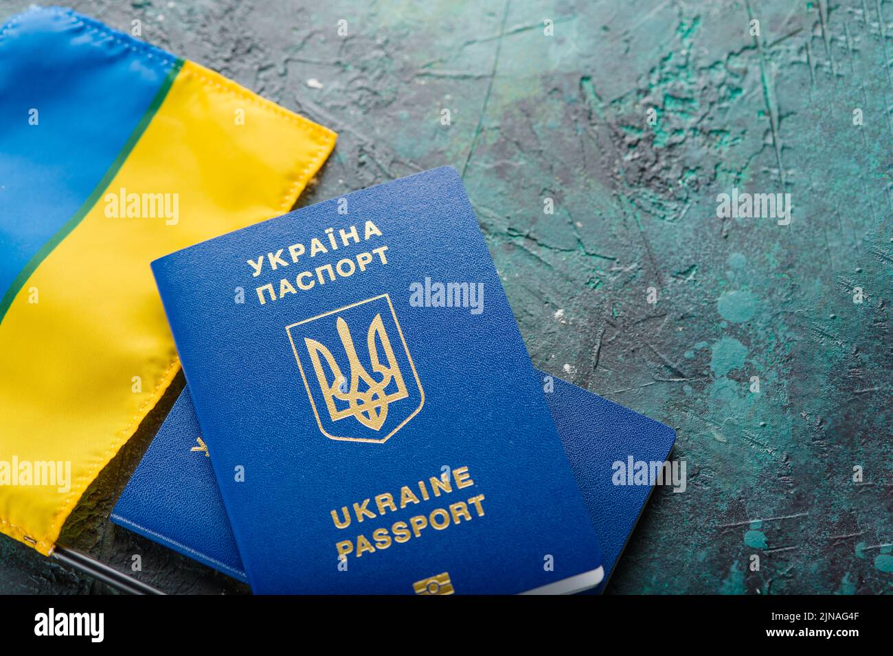 Two Ukrainian biometric passports and a Ukrainian yellow and blue flag ...