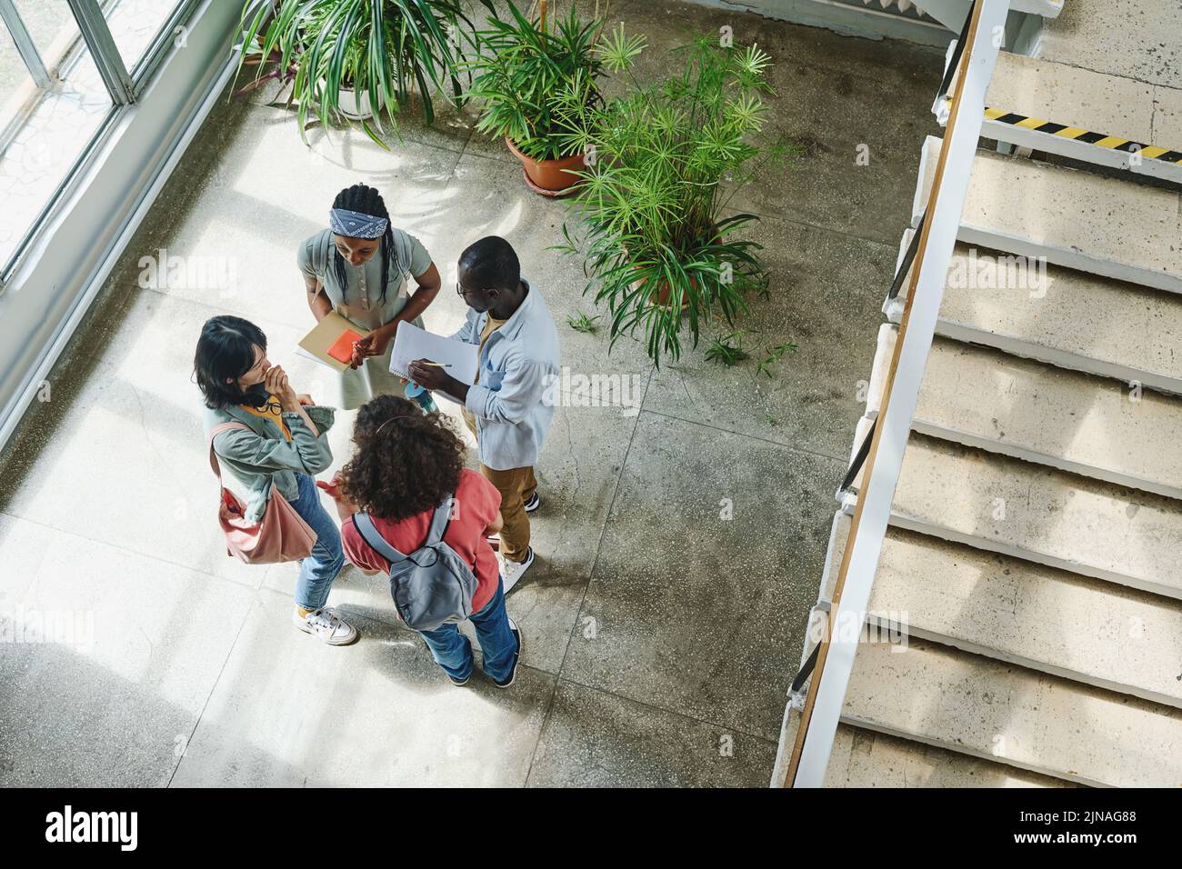 High angle view of group of students standing at corridor and preparing ...