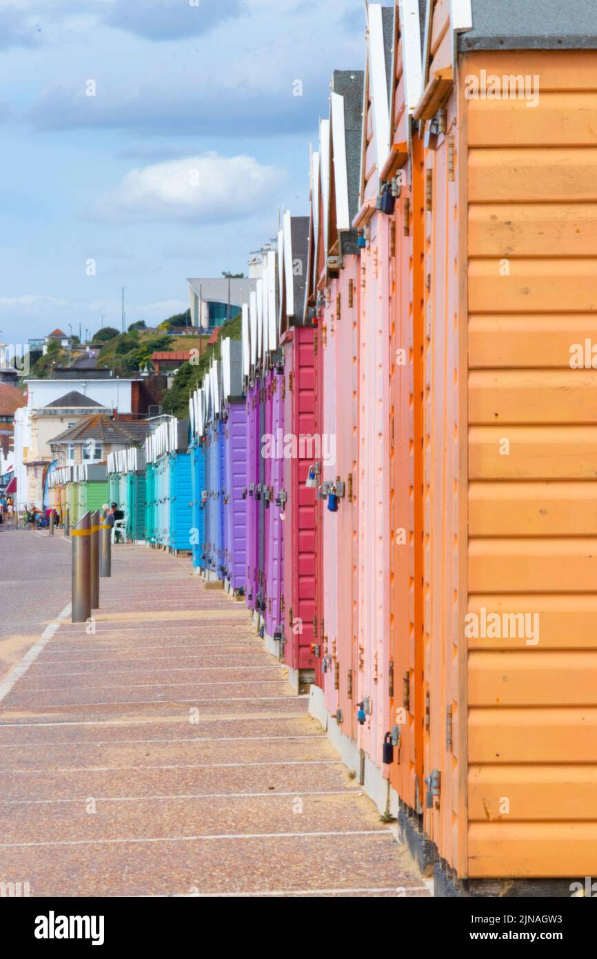 perspective row of multicoloured wooden beach huts by the sea ...