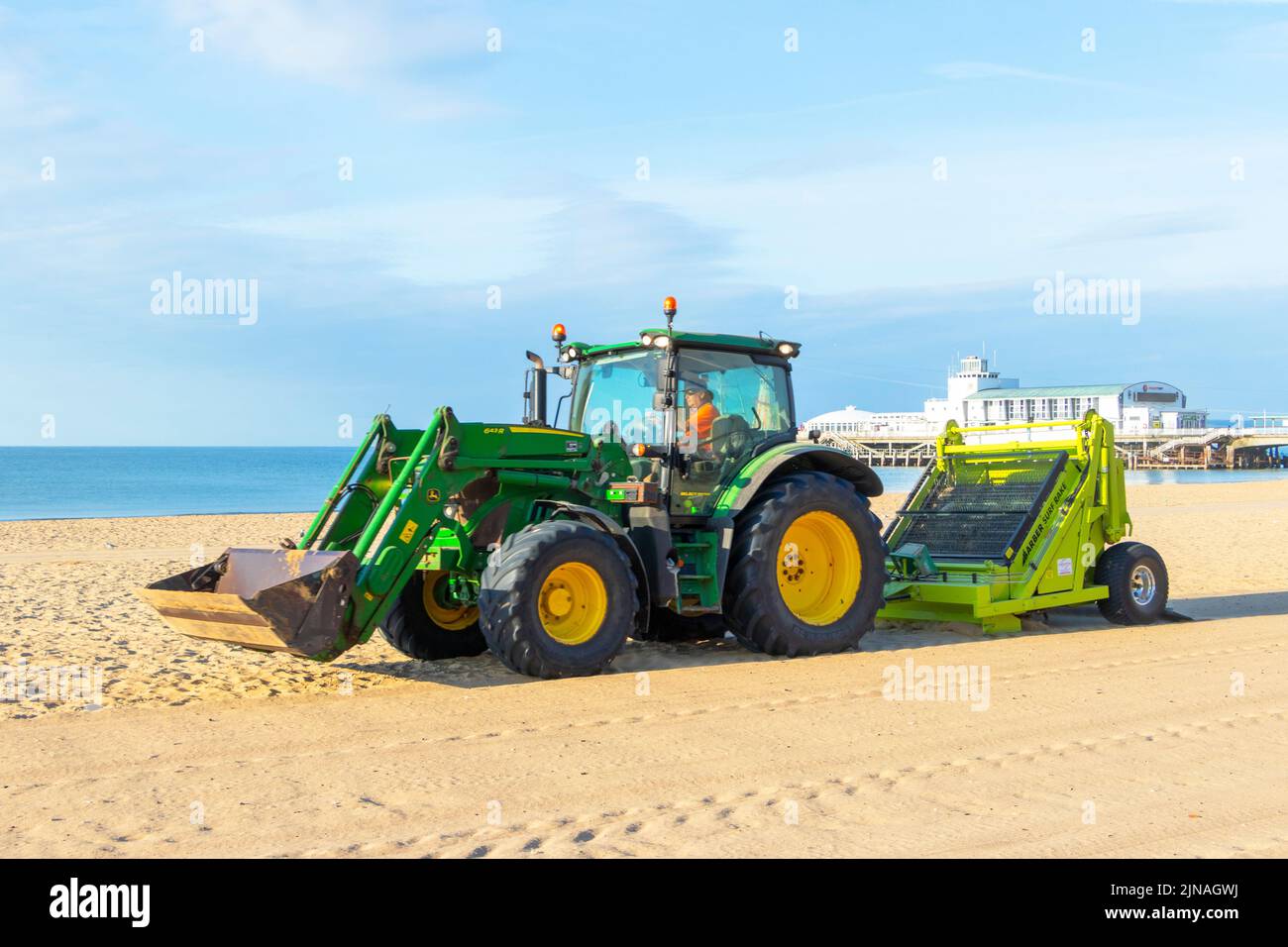 green council municipal tractor and grader smoothing raking the beach ...