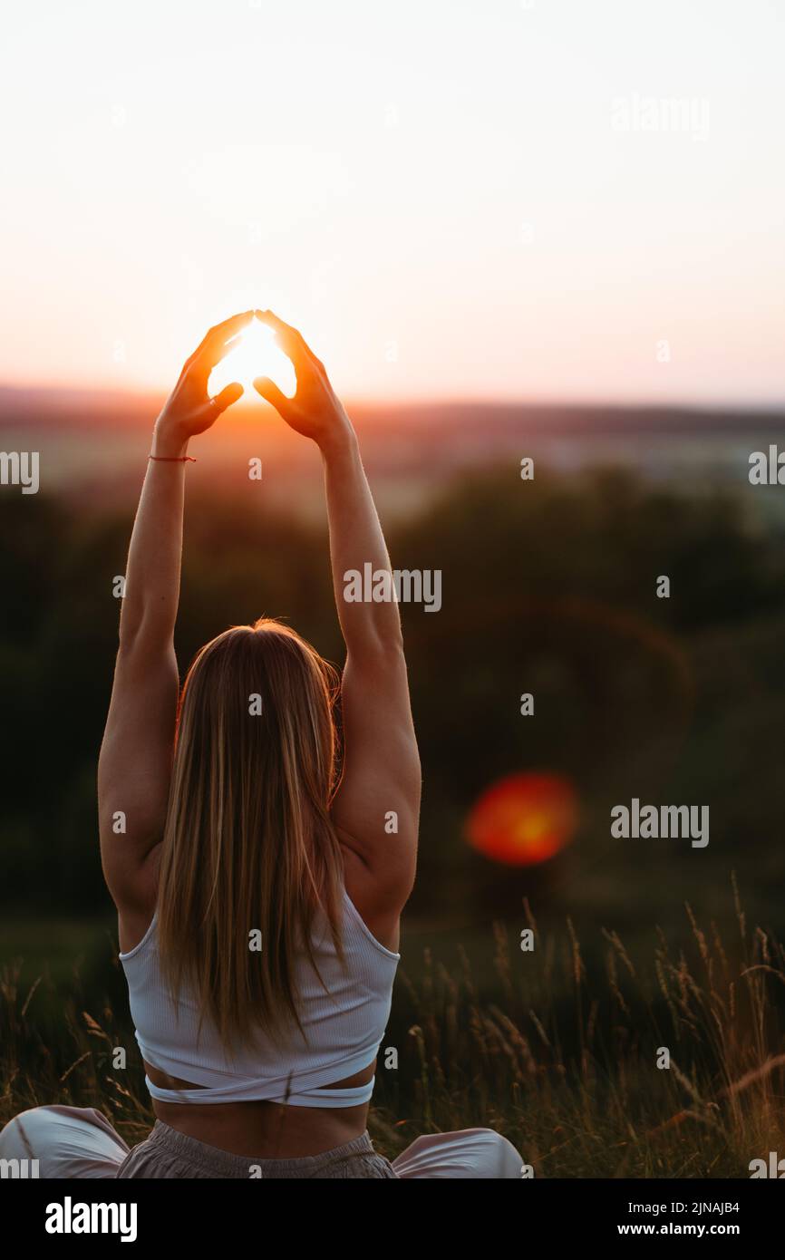 Back View on Woman Sitting in Meditation Yoga Pose and Catching Sun by ...