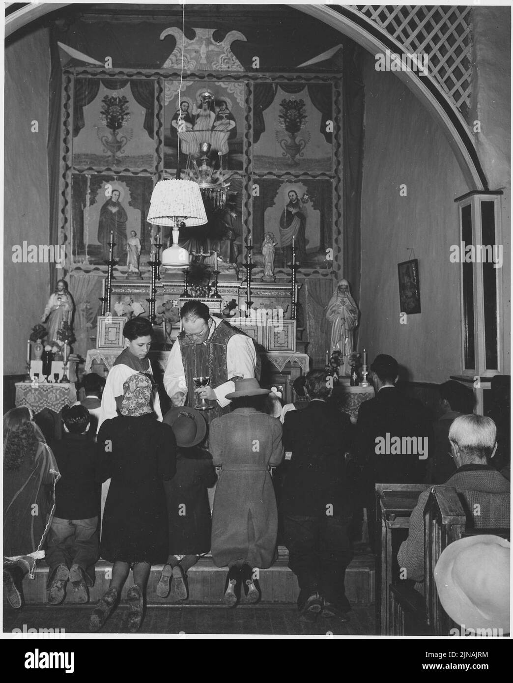 Taos County, New Mexico. Father Morgan administers sacrament during ...