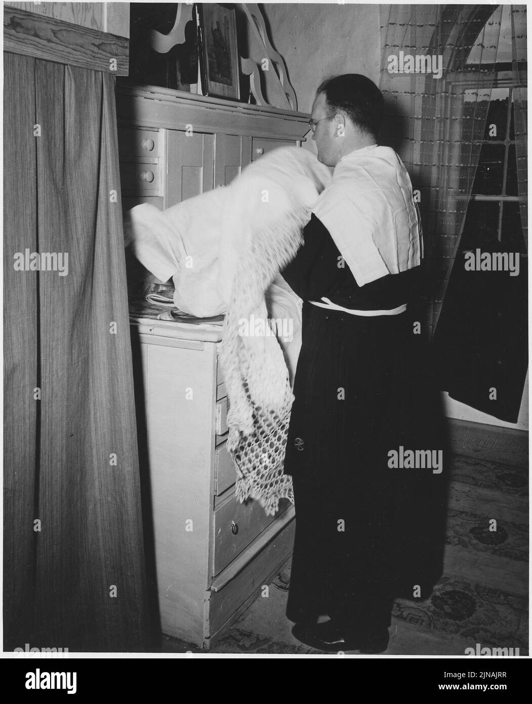 Taos County, New Mexico. Father Morgan puts on vestments for Mass in ...