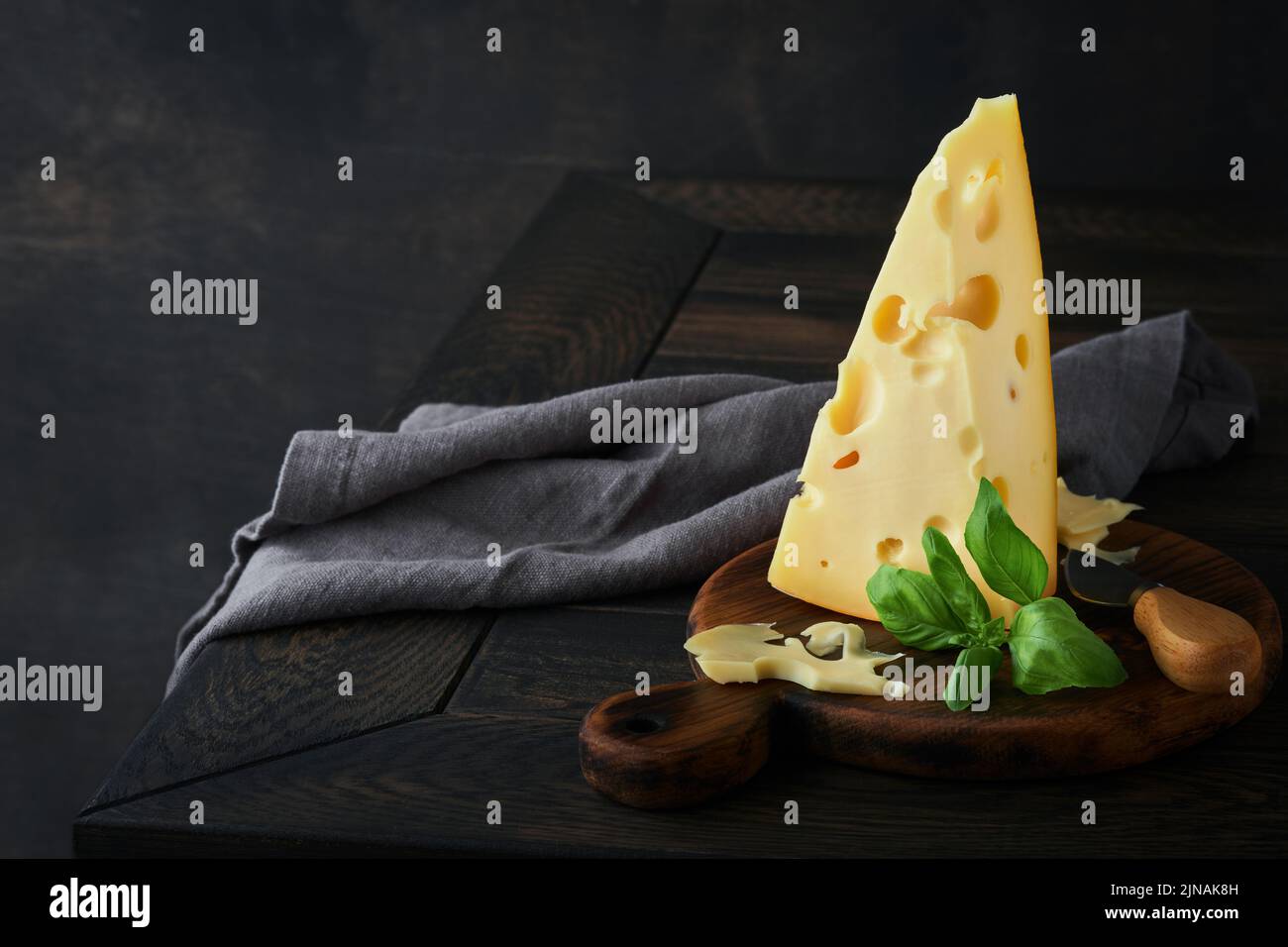 Cheese. Piece of cheese triangle, Swiss cheese on with basil and a ...