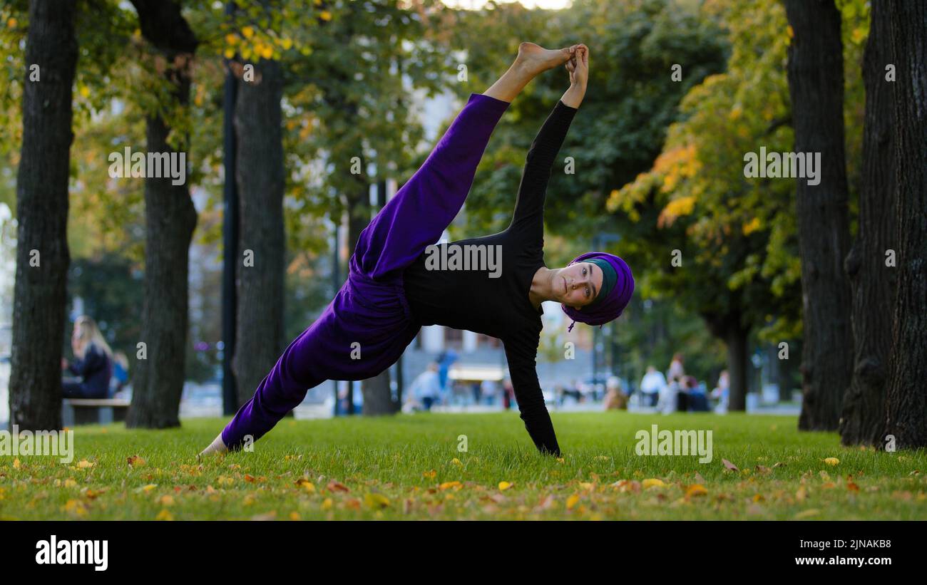 Strong sportive islamic girl in hijab yoga teacher woman stands in side ...