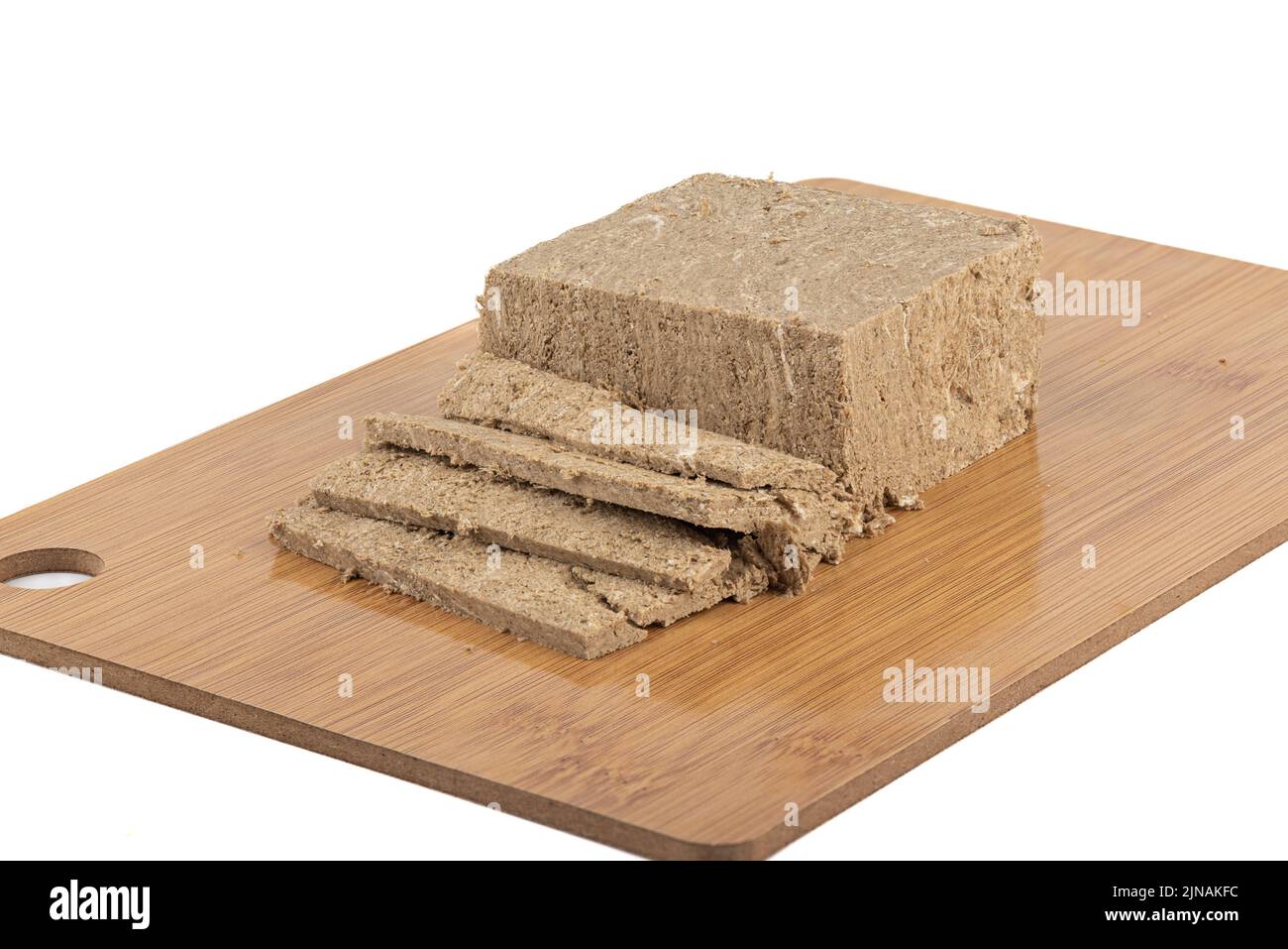 Sliced sunflower halva on a cutting board over a white background. Halva is a kind of oriental ...