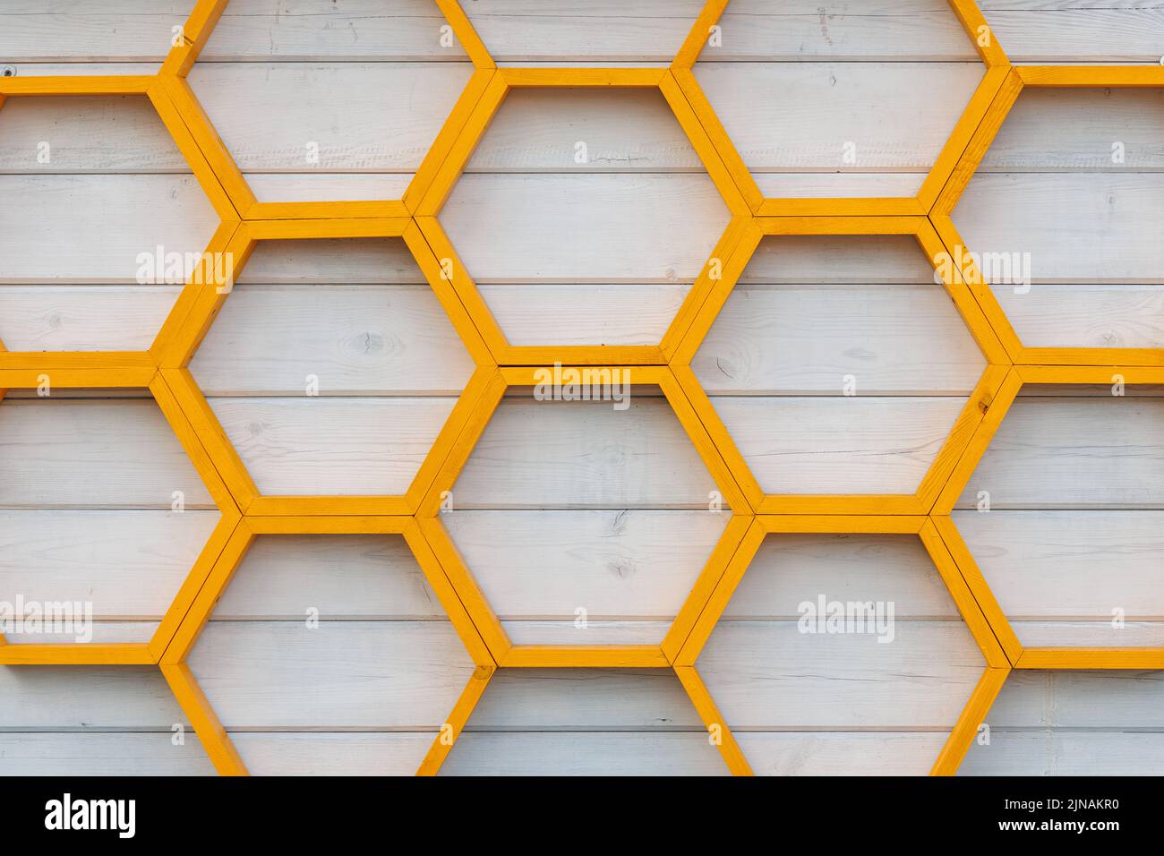 yellow honeycomb pattern wooden shelf on white painted wooden plank ...