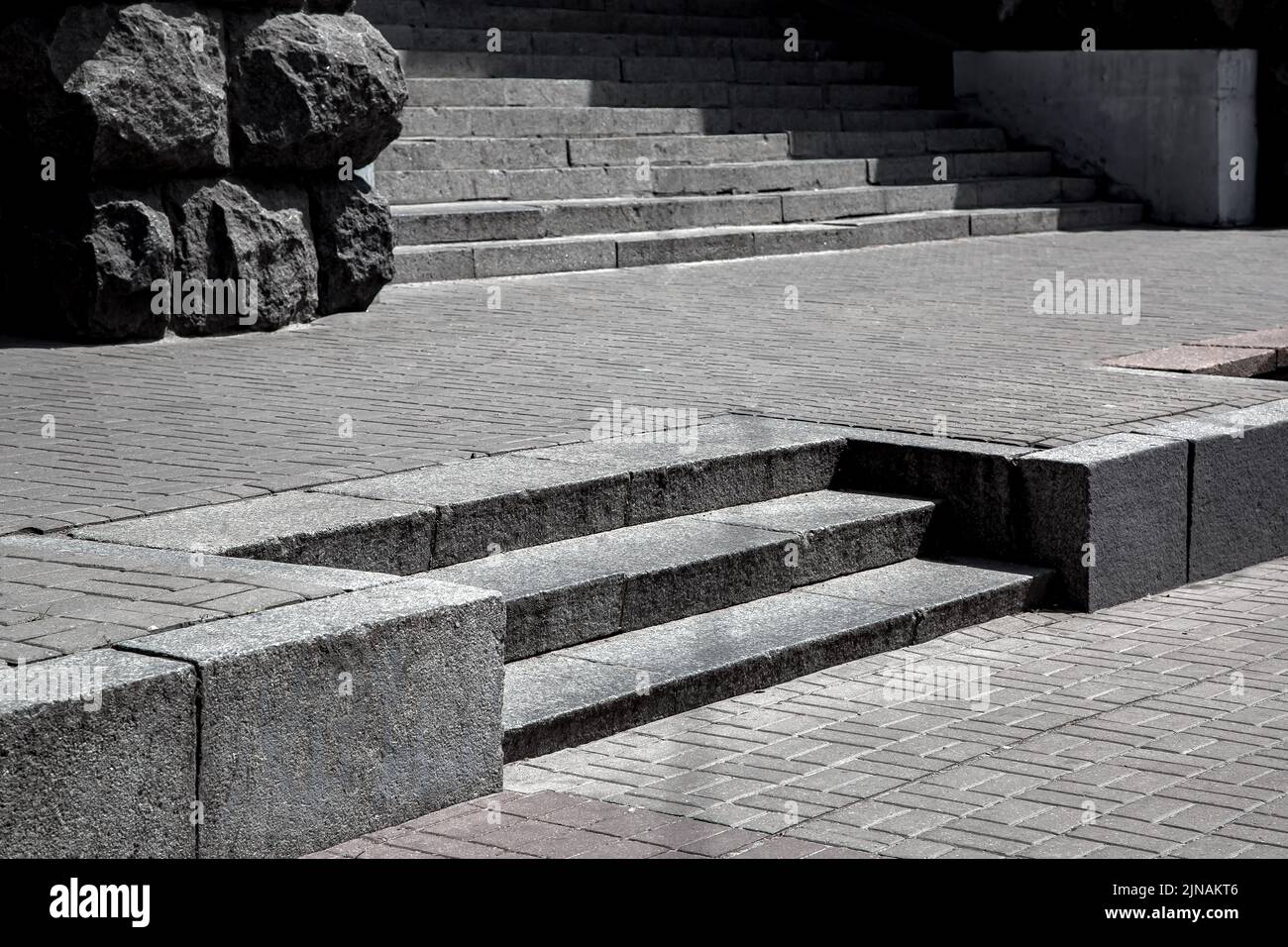 Gray granite steps in the middle of stone tile street pavement brick ...