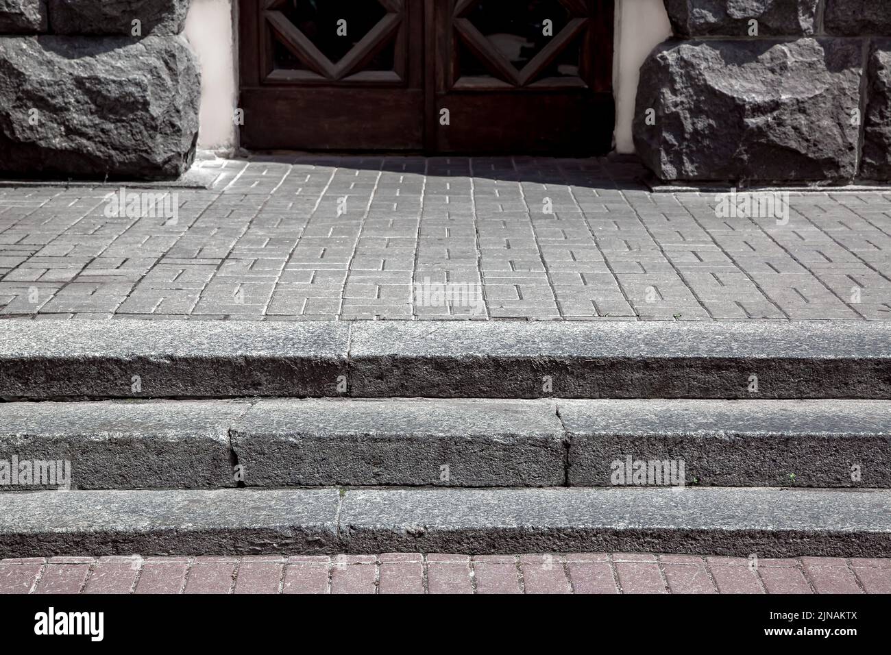 granite steps on a pedestrian pavement made of stone tiles near a ...