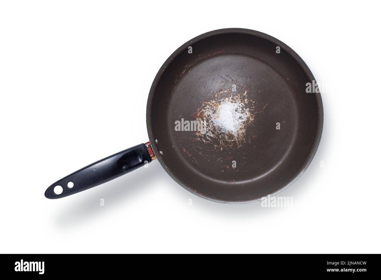 An old used frying pan showing scratches and cooking stains, isolated ...