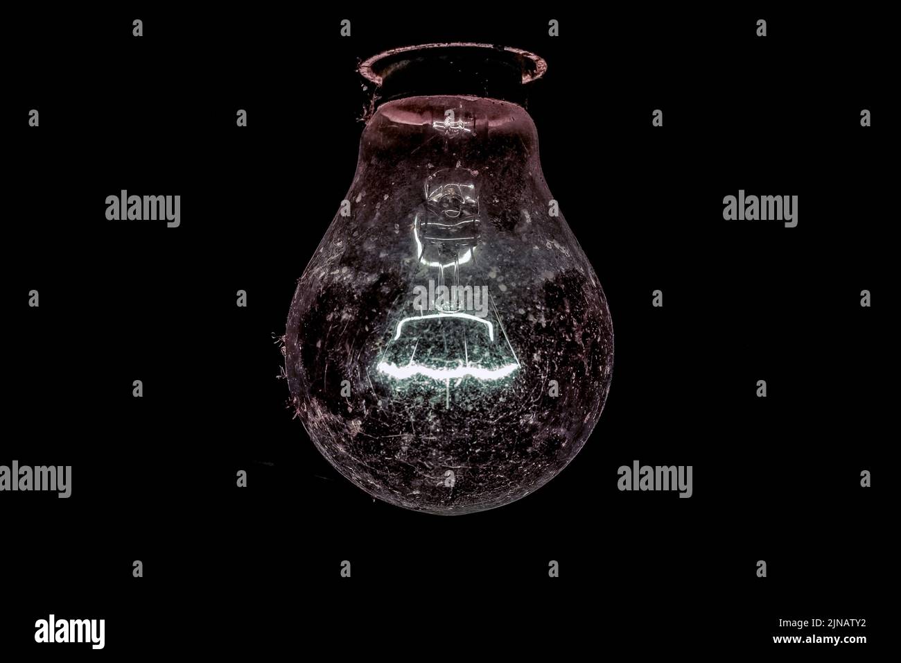 Tungsten light bulb lit on black background Stock Photo - Alamy