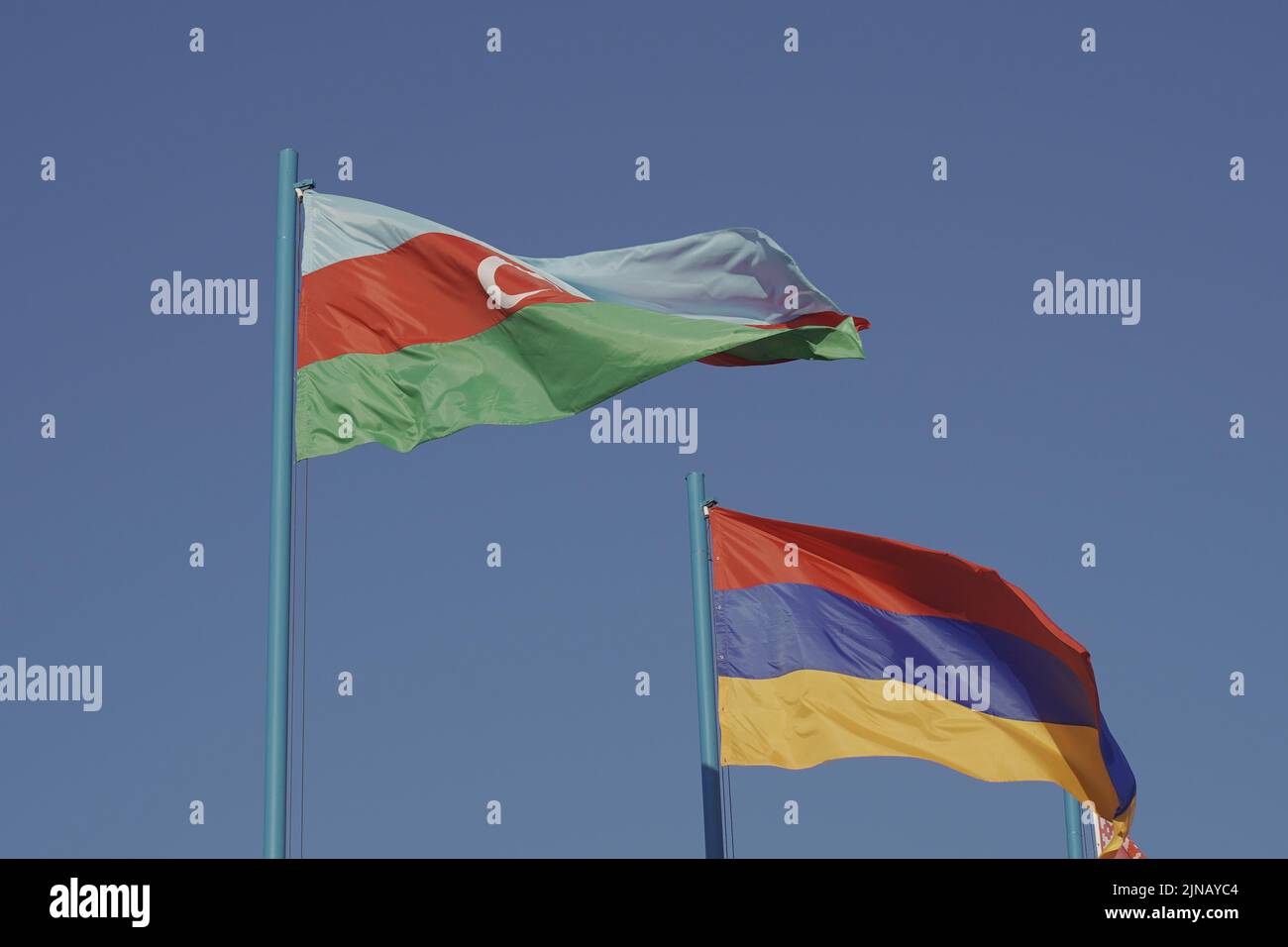 The national flags of Azerbaijan and Armenia are fluttering in the wind ...
