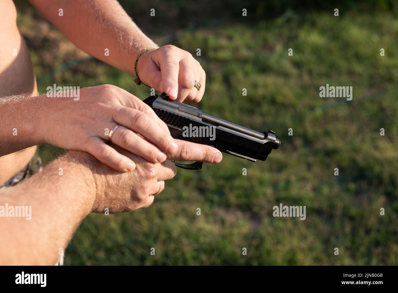 The man holds a gun in his hands and shows his work. learning to use a ...