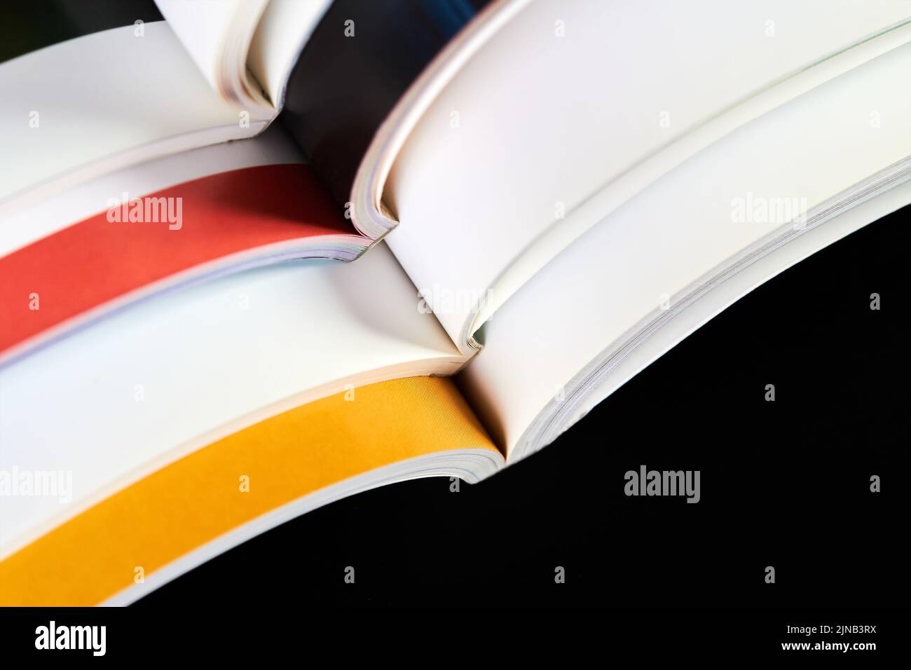 A part of a stack of open magazines on dark background Stock Photo - Alamy