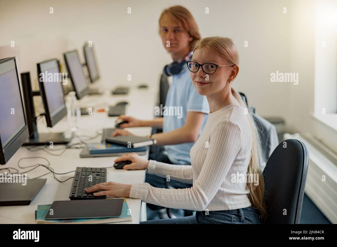 Focused university student using computer studying in computer room and ...
