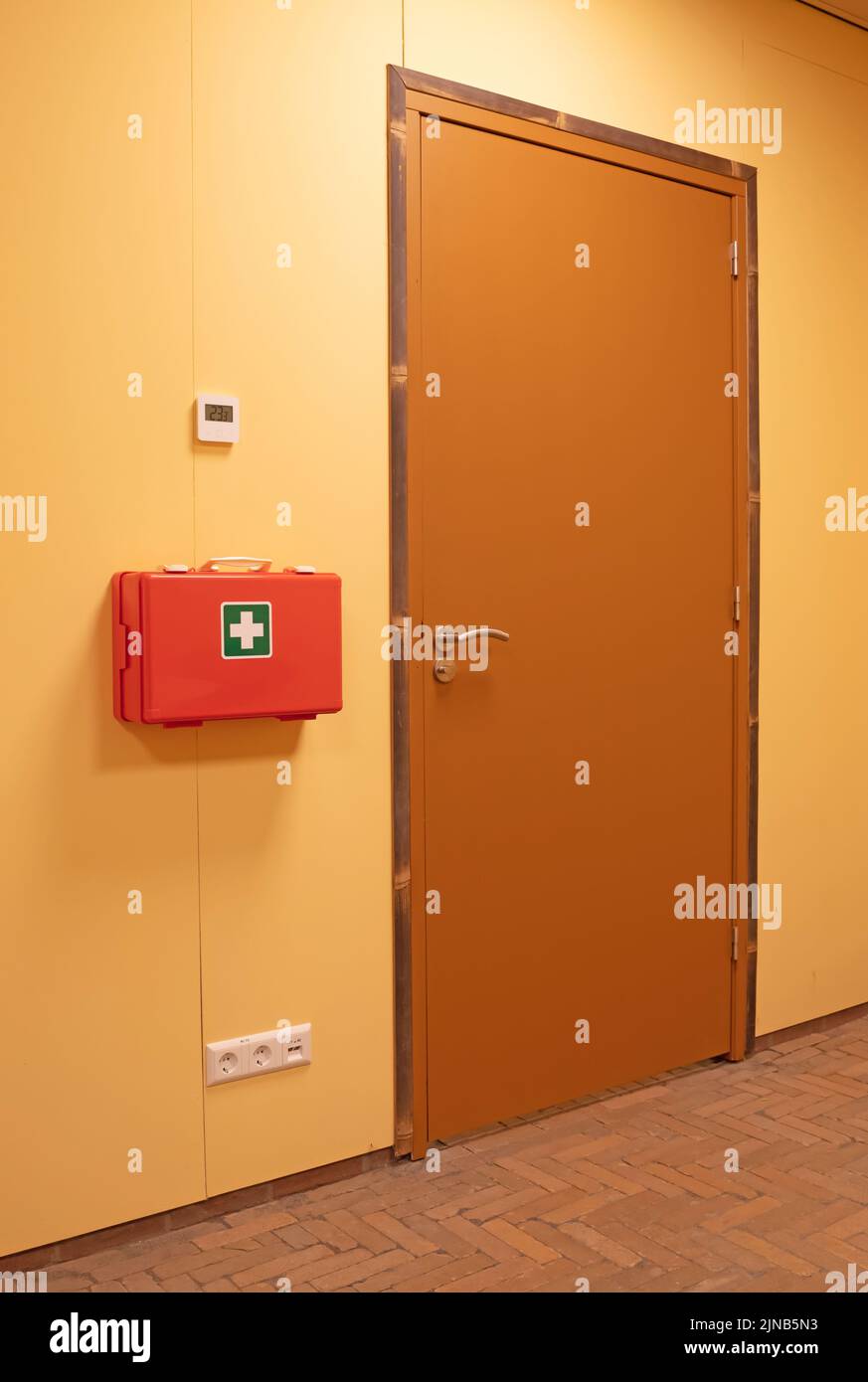 Orange first aid case hanging on the wall for safety measures Stock ...
