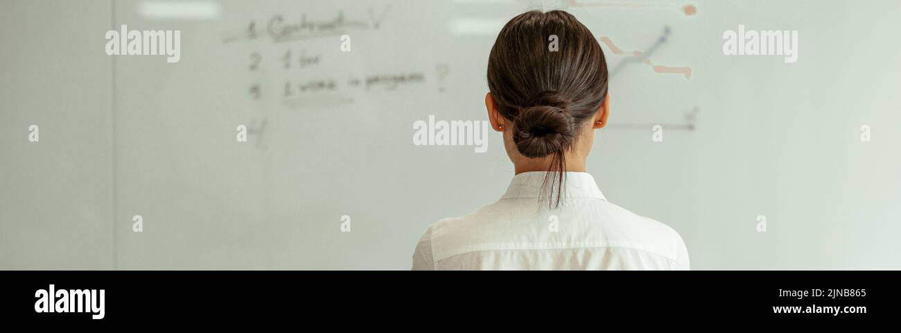 Business woman looks at flipboard with charts and plans. View from the ...