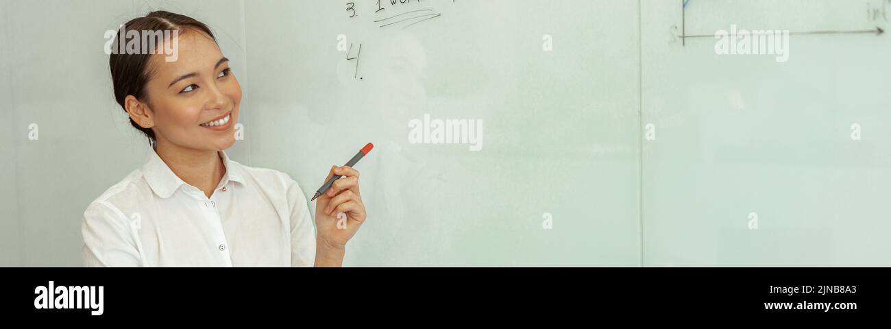 Asian business woman looking on flipboard with charts stand in meeting ...