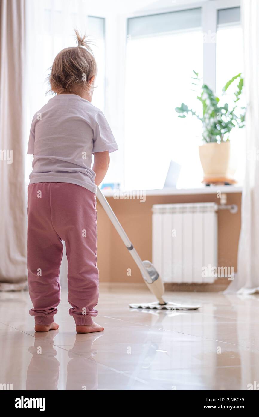 little daughter cleaning in the house, child dusting, Cute little ...