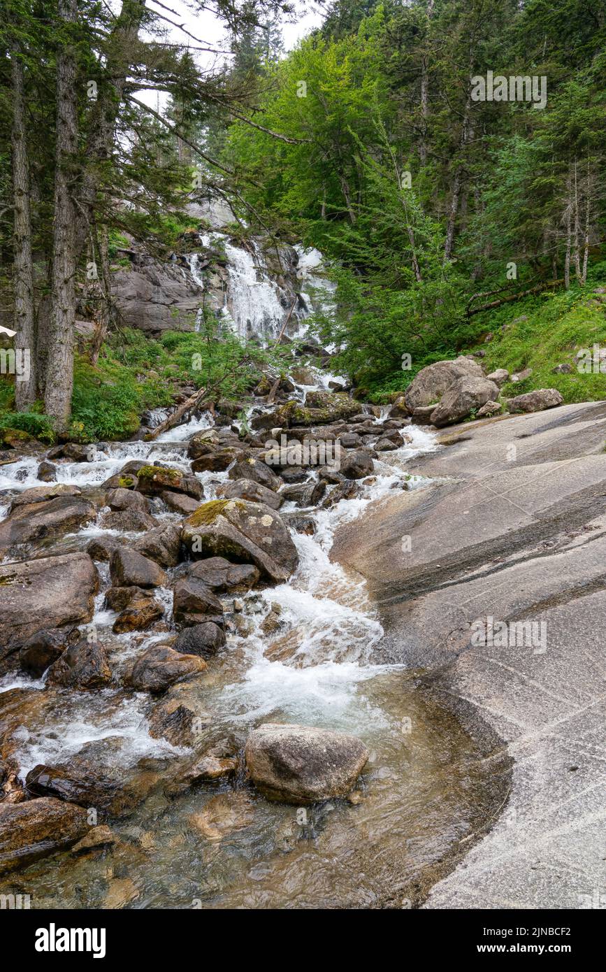 a large teired woodland waterfall, white water crashing over boulders ...